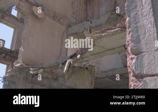 Large ruined building with pile of construction debris and concrete ...