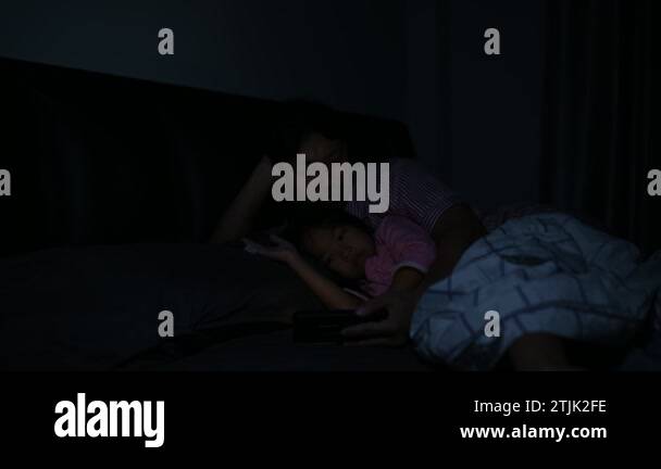 Dad and daughter sleep on the bed in bedroom, Watch cartoon with phone ...