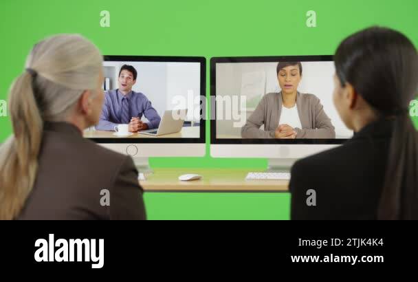 A team of office professionals chat over a video conference call on ...