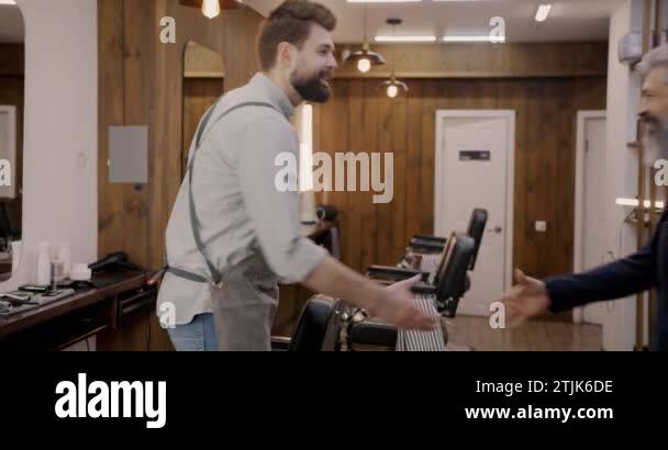 Happy client and barber two men shaking hands talking preparing for ...