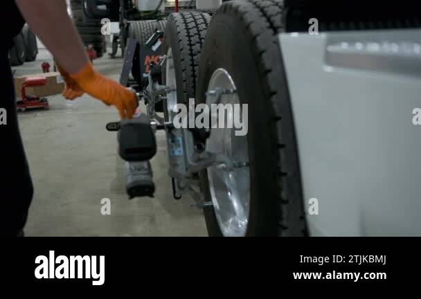 The mechanic alignment the wheels in truck stands on a alignment stand ...