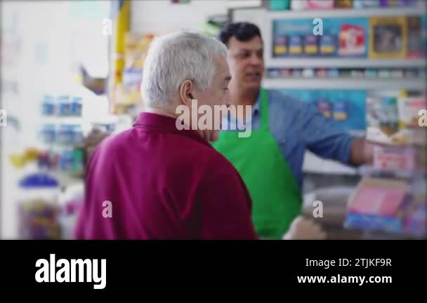Back of senior customer buying goods at grocery store interacting with ...