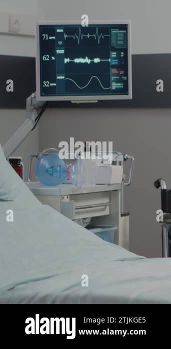 Vertical video: Empty hospital ward with heart rate monitor and bed for ...