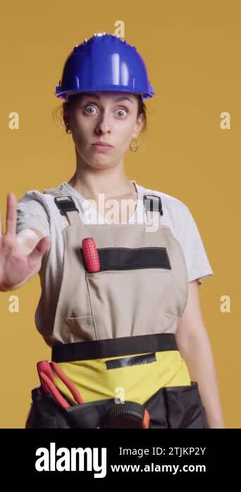 Vertical video: Portrait of construction worker doing stop sign with ...