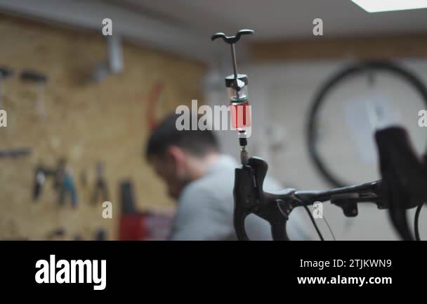 Bicycle mechanic holding syringe with brake fluid during brake bleeding ...
