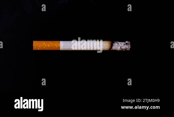 Cigarette smoldering 4K time-lapse video, isolated on black background ...