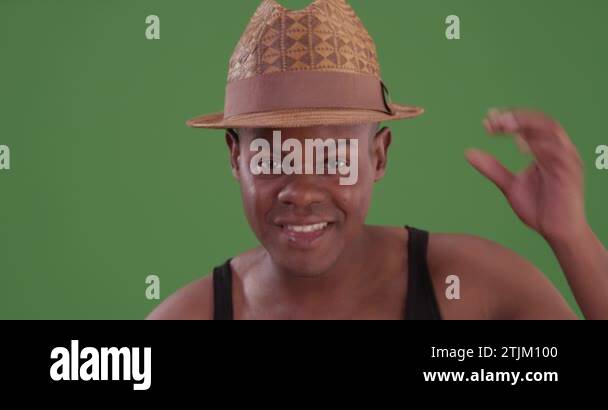 Black man poses happily for a portrait on green screen. On green screen ...