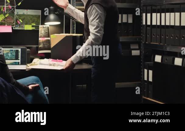 Two investigators review evidence and incriminating proof to find ...