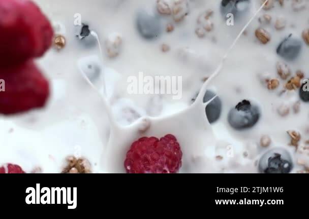 Raspberry throwing splashing yoghurt top view. Calcium oat liquid with ...