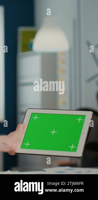 Woman holding tablet with green screen mockup display standing in busy ...
