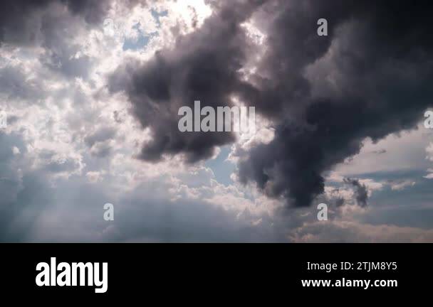 Rain clouds move in the sky, timelapse. Background of gray cumulus thick storm clouds in cloudy ...