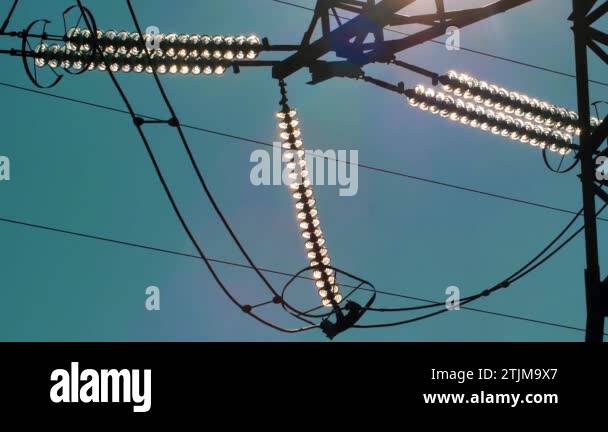 Power lines with sun rays on blue sky. High voltage substation ...