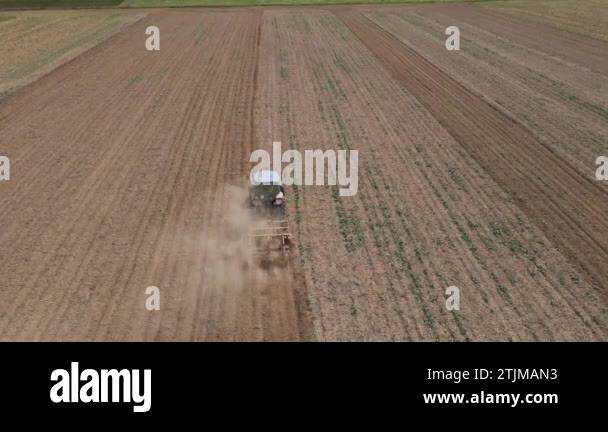 Drone flying over farm tractor working in agricultural field, column of ...