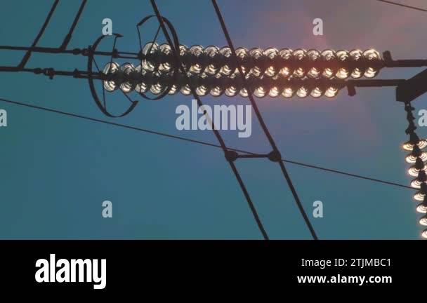 Power lines with sun rays on blue sky. High voltage substation ...