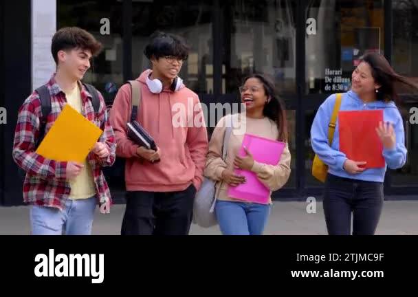 Group of four students walking in a campus university outdoors. Teenage ...
