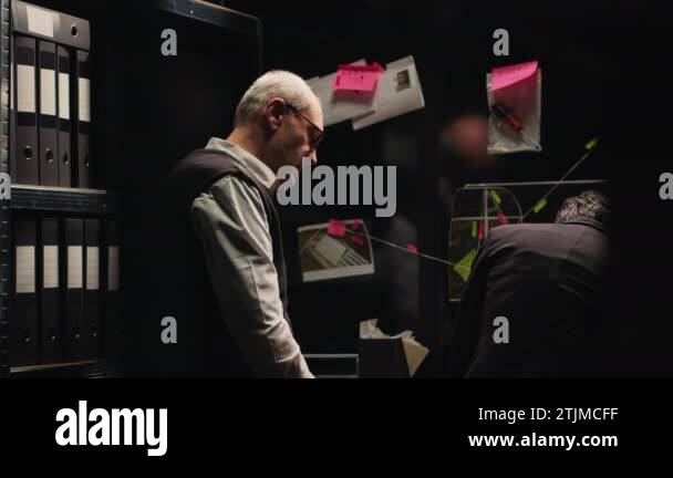 Police agents examine evidence board in investigation office, analyzing ...