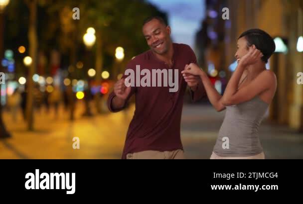 Playful African-American couple dancing together on the Champs-Elysees ...
