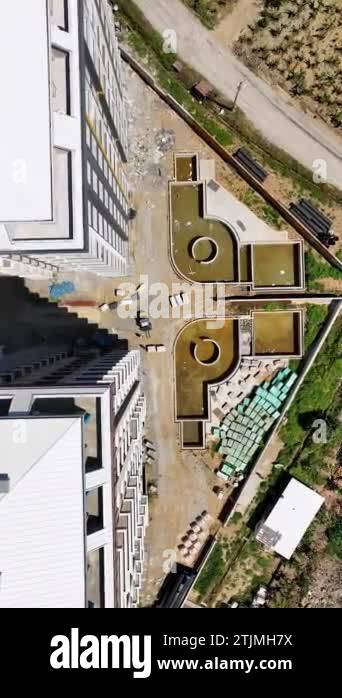 Step into the future with this vertical video, offering an aerial view of a high-rise under ...