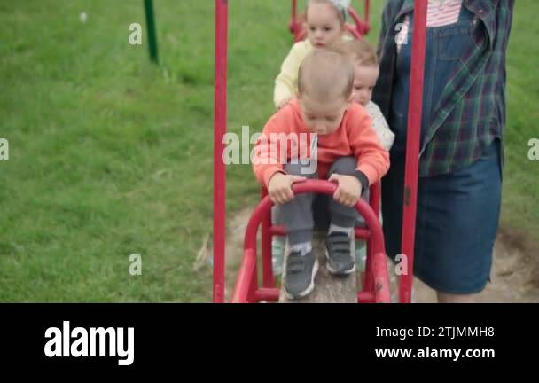 Cute pretty Preschool children with young mom frolic in swing train on ...