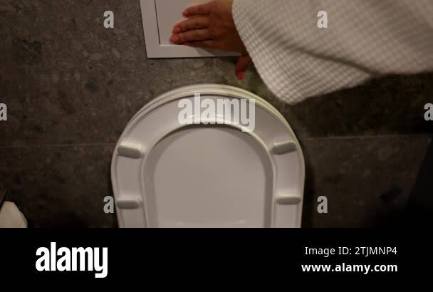 Female hand presses button on toilet flush. Flushing water using double ...