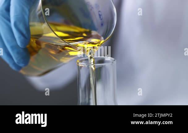 Scientist chemist pouring motor oil into test tube closeup 4k movie ...