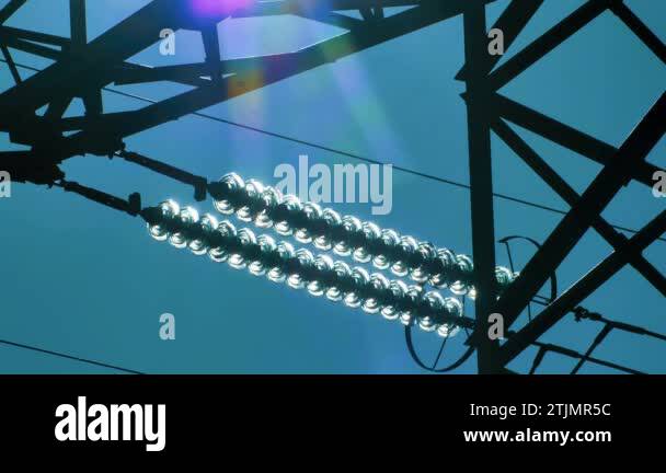 Power lines with sun rays on blue sky. High voltage substation ...