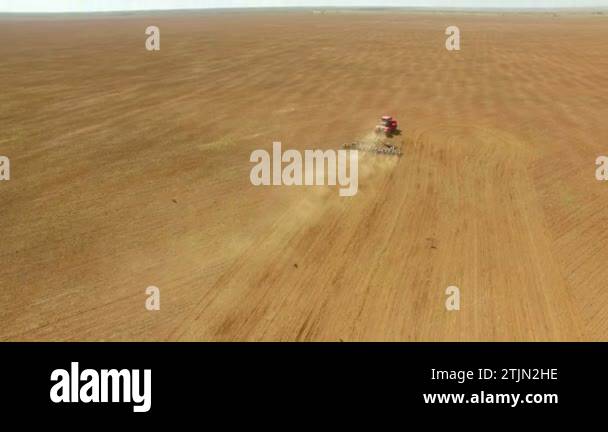 Aerial footage of vintage harvester, harvesting hay paddock in rows ...