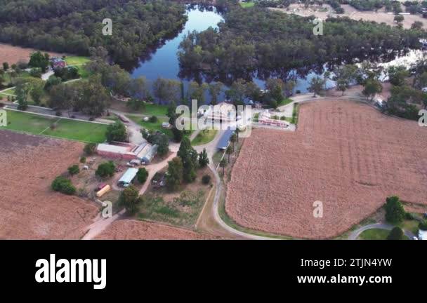 A farmers house sits between the bank of the River and a rural farm ...