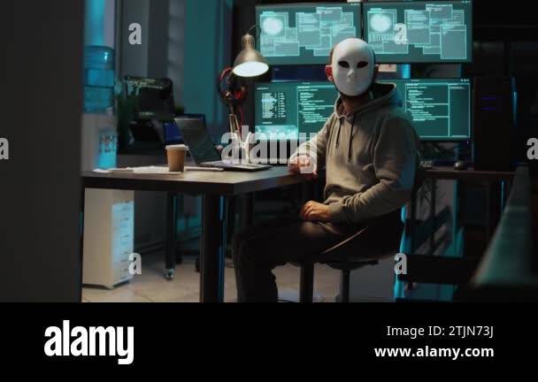Web terrorist wearing mask hacking database servers, hacker with hood breaking into computer ...