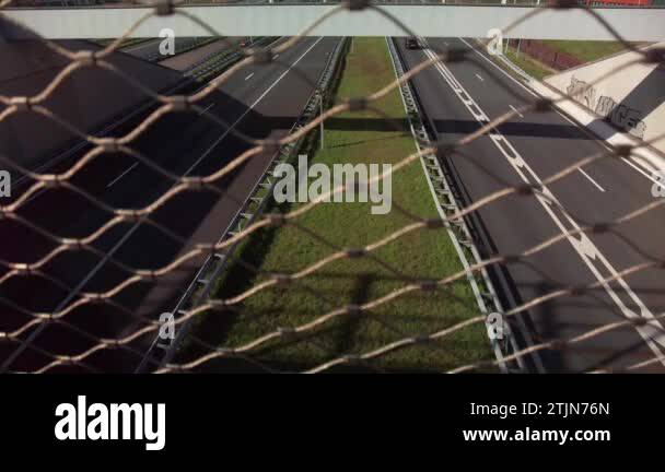 Rear view from above the overpass, vehicles drive out of the tunnel on ...