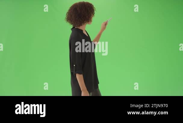 A young black female teacher explains math on green screen. On green ...