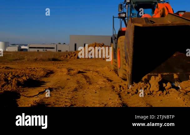 Construction equipment. Construction tractor with bucket in sand and ...