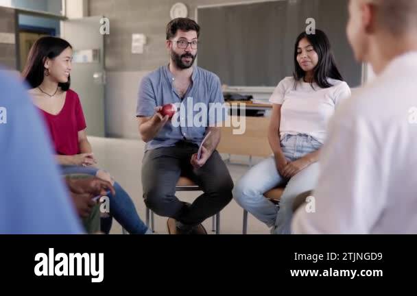 Male teacher and diverse students working together during brainstorming ...