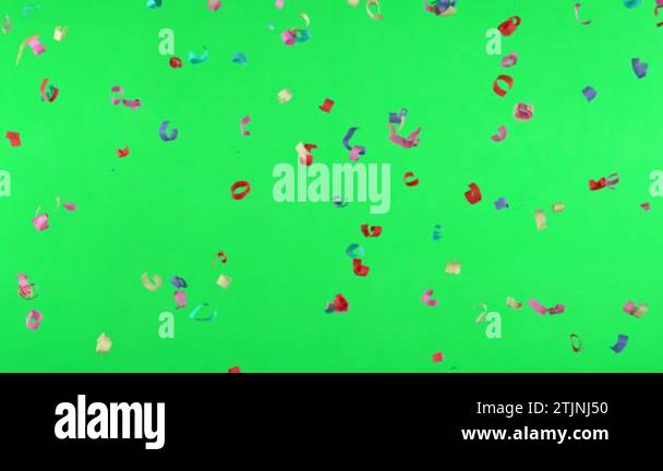 Super slow motion of flying colored confetti isolated on green ...