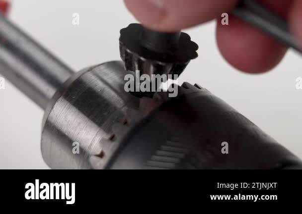 Changing the drill bit of an electric drill. Rotation of manual gear ...