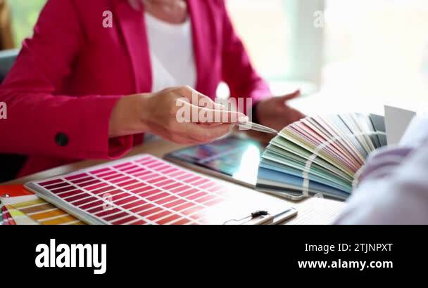 Man and woman discuss new paint colors comparing shades on set of color ...