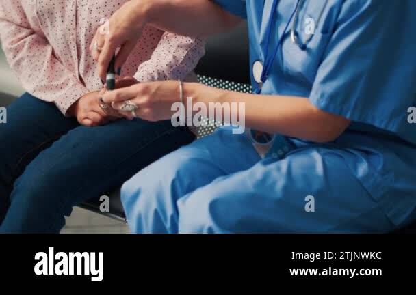 Nurse doing insulin level measurement with glucometer to help patient ...
