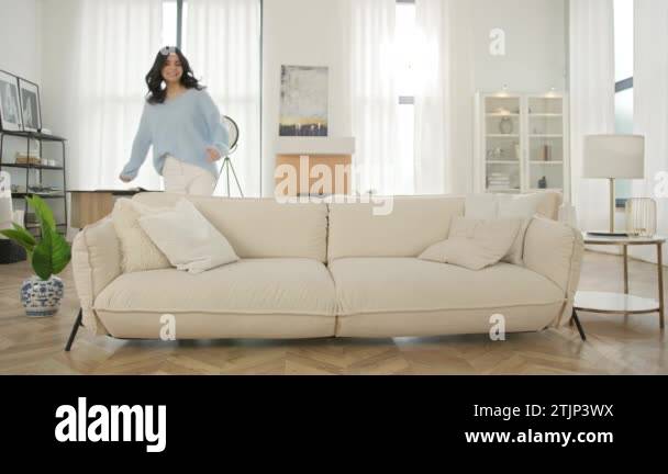 Design interior furniture. Happy Latin American woman jumping on modern ...