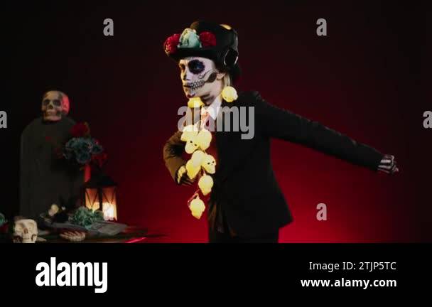 Scary woman with costume of death dancing in studio, listening to music ...