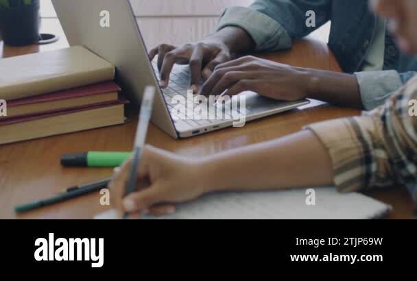 Close-up of hands male and female writing in notebook and typing with ...