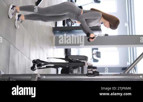 Vertical video of a sporty girl doing arm exercises, training triceps ...