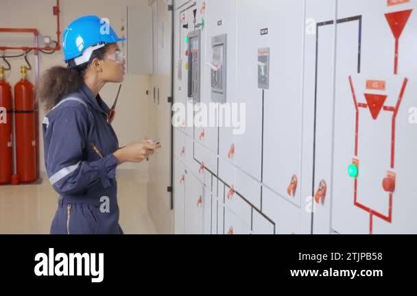 Electrical young woman engineer examining maintenance cabinet system ...