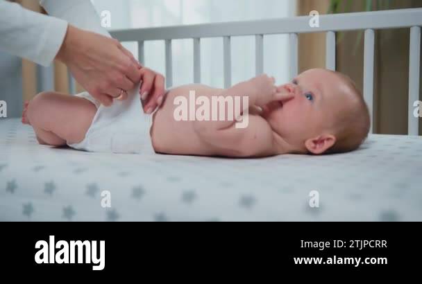 Side view portrait of small baby when his mother changing diaper on the ...