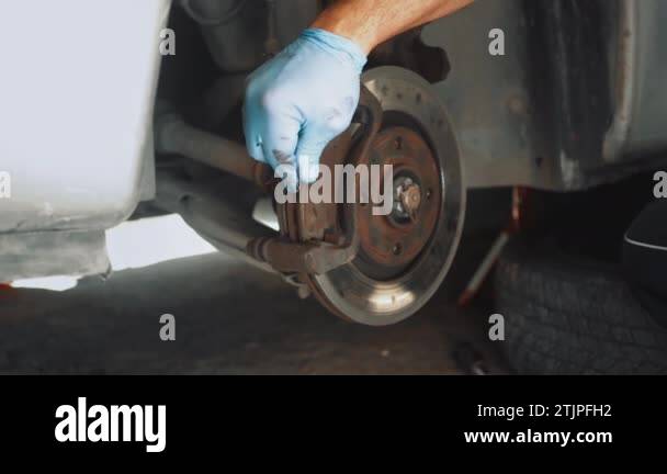 vehicle maintenance. Auto mechanic working on car brakes in mechanics ...
