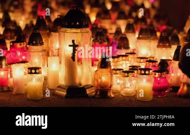 Candle lights on graves and tombstones in cemetery at night in Poland during All Saints Day ...