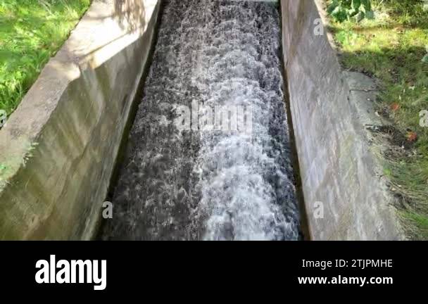 Water flows violently through wide and deep drainage channel in the ...