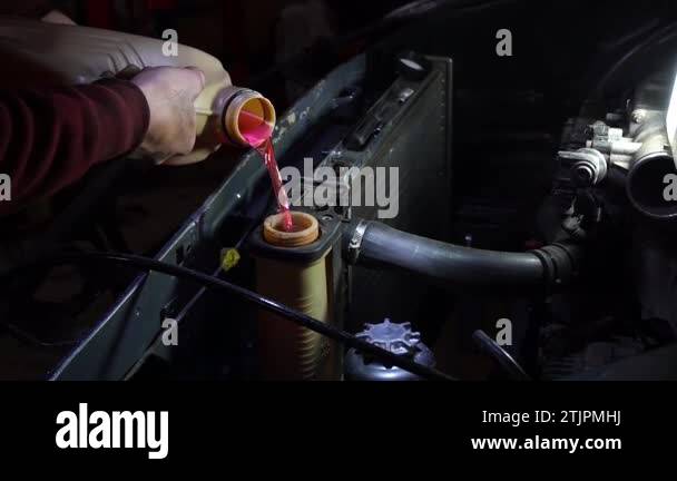 car repair, the mechanic pours coolant and lubricant into the engine ...