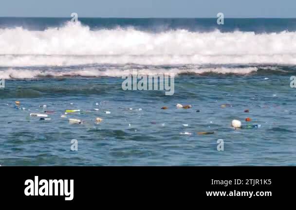 Garbage floating on the surface of the sea along the coastline. The ...