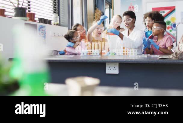 Diverse female teacher and happy schoolchildren having science class in ...