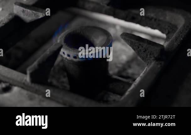 Gas burner of an old kitchen stove with burning gas close-up in motion ...